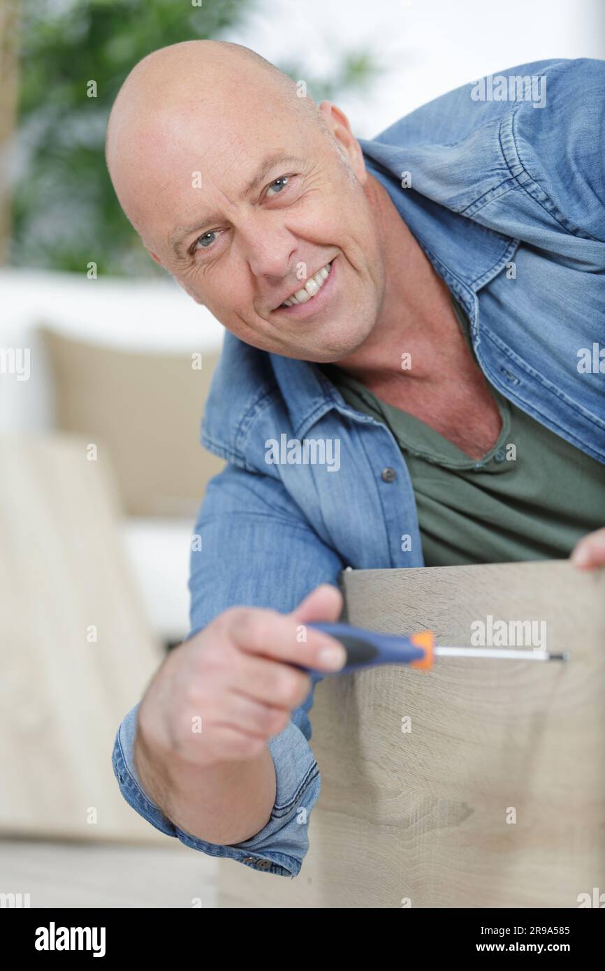 working man using screwdriver indoors Stock Photo - Alamy