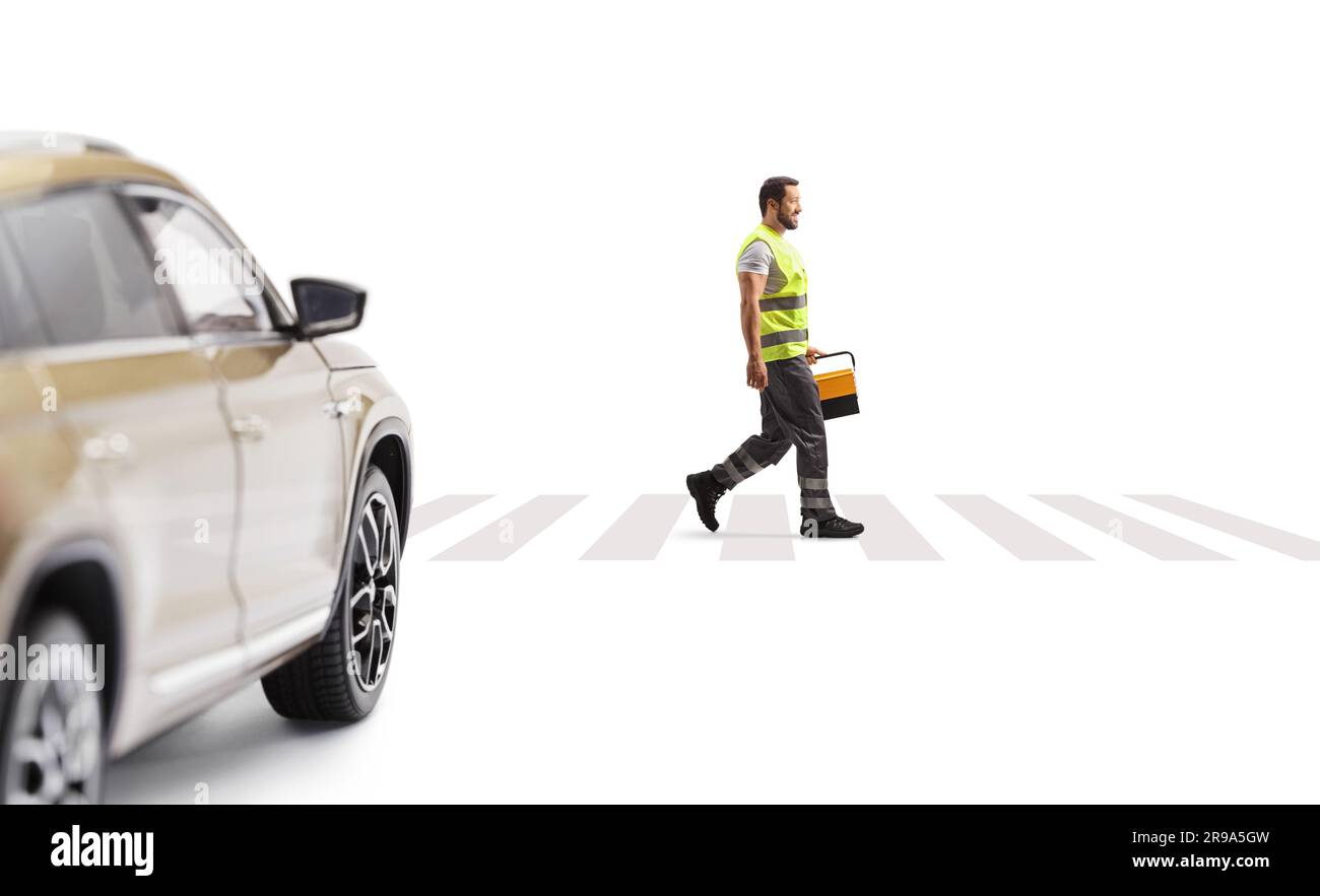 Road assistance mechanic walking at a pedestrian crosswalk in front of ...