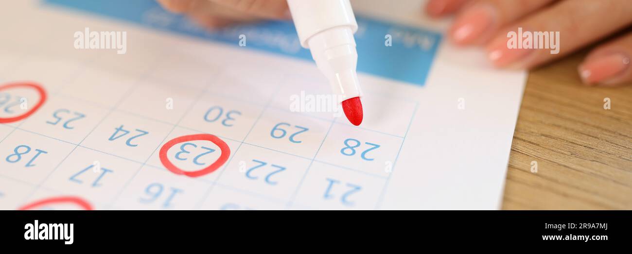 Female hand marking dates in calendar with red marker Stock Photo - Alamy