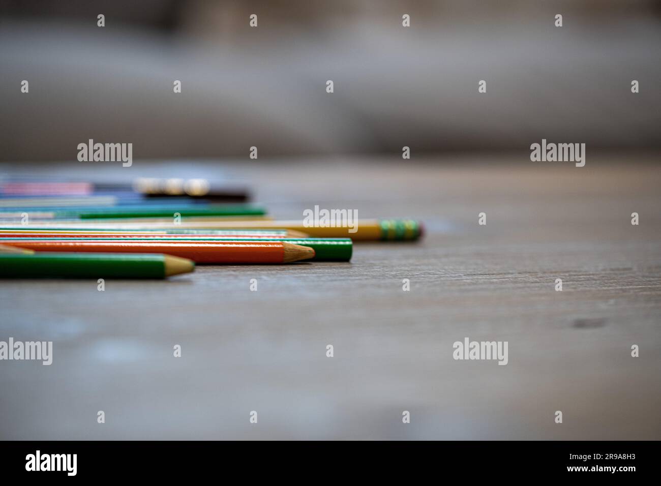 A colorful array of pencils neatly arranged in a line on a flat surface ...