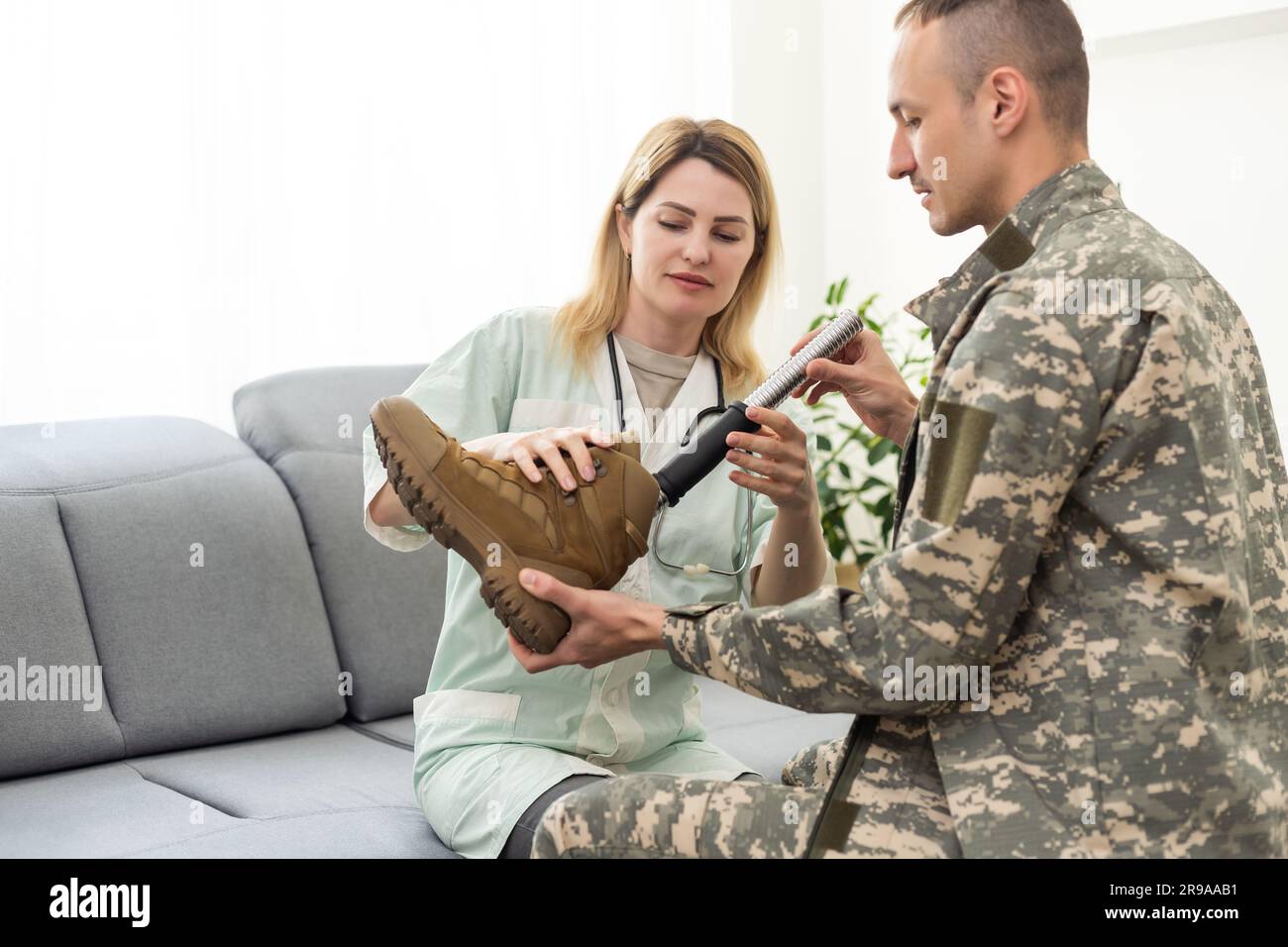 Portrait of military veteran fixing prosthetic leg and wearing army ...