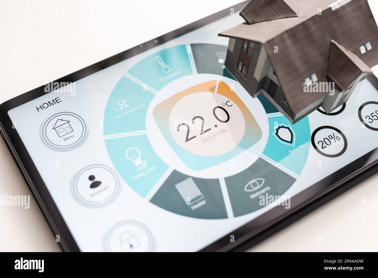 Small house model is on screen tablet and icons home electronics ...