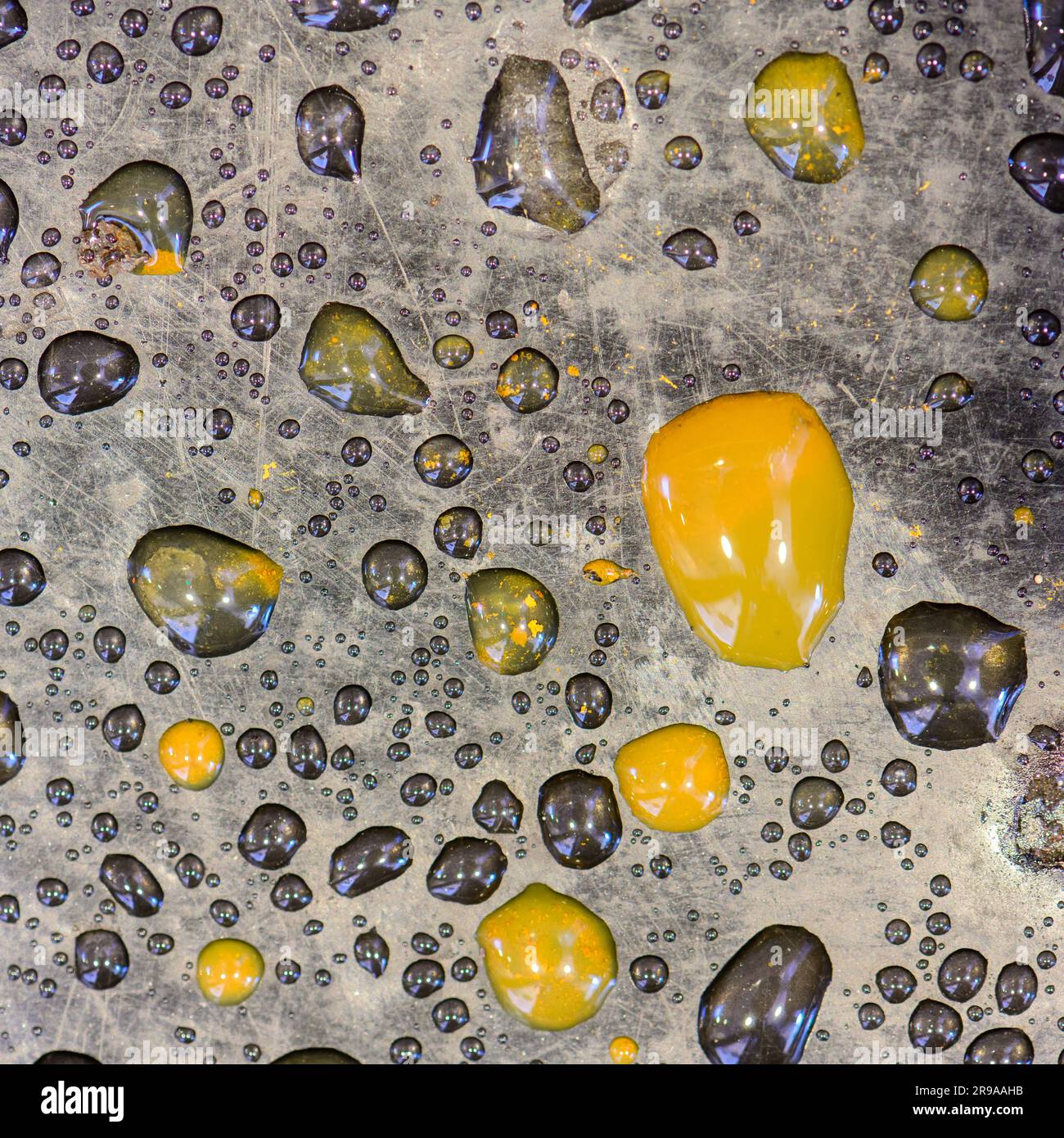 Black and yellow water drops on an oily surface Stock Photo - Alamy