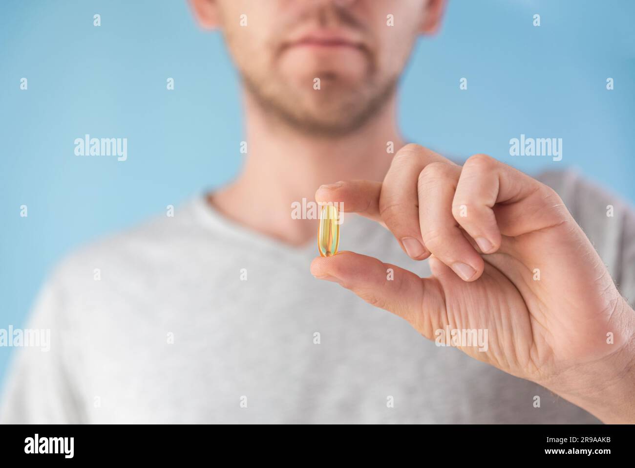 Man holding capsules with omega 3, vitamin D in hand. Nutritional ...