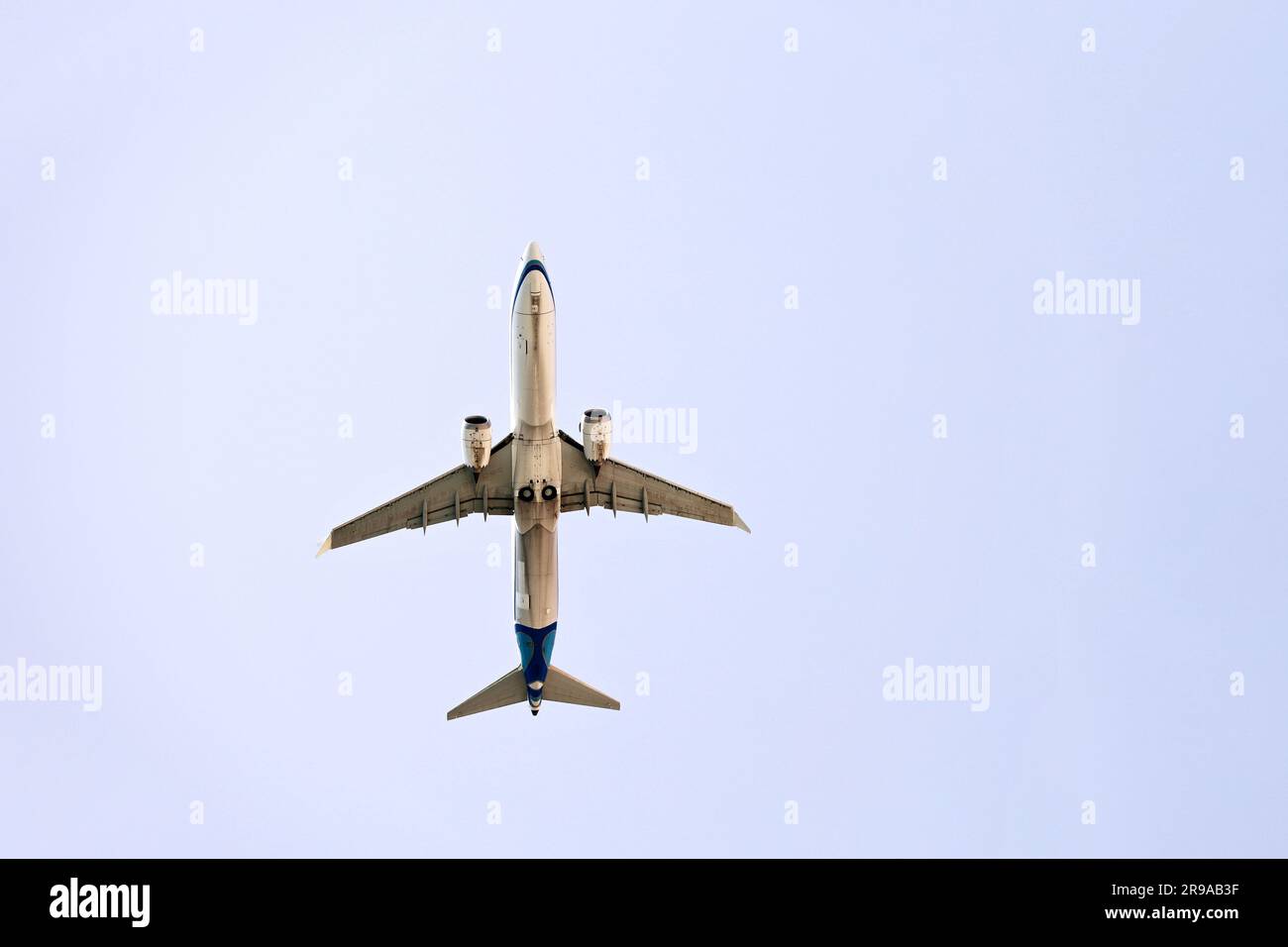 Airplane flying in the clear sky, bottom view. Commercial plane taking ...