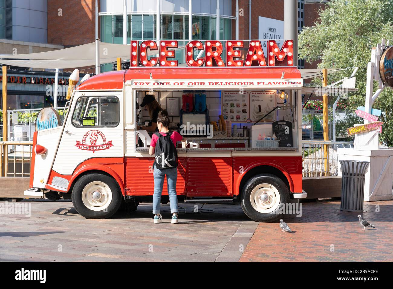 A woman buying an ice cream from an ice cream van selling award winning ...