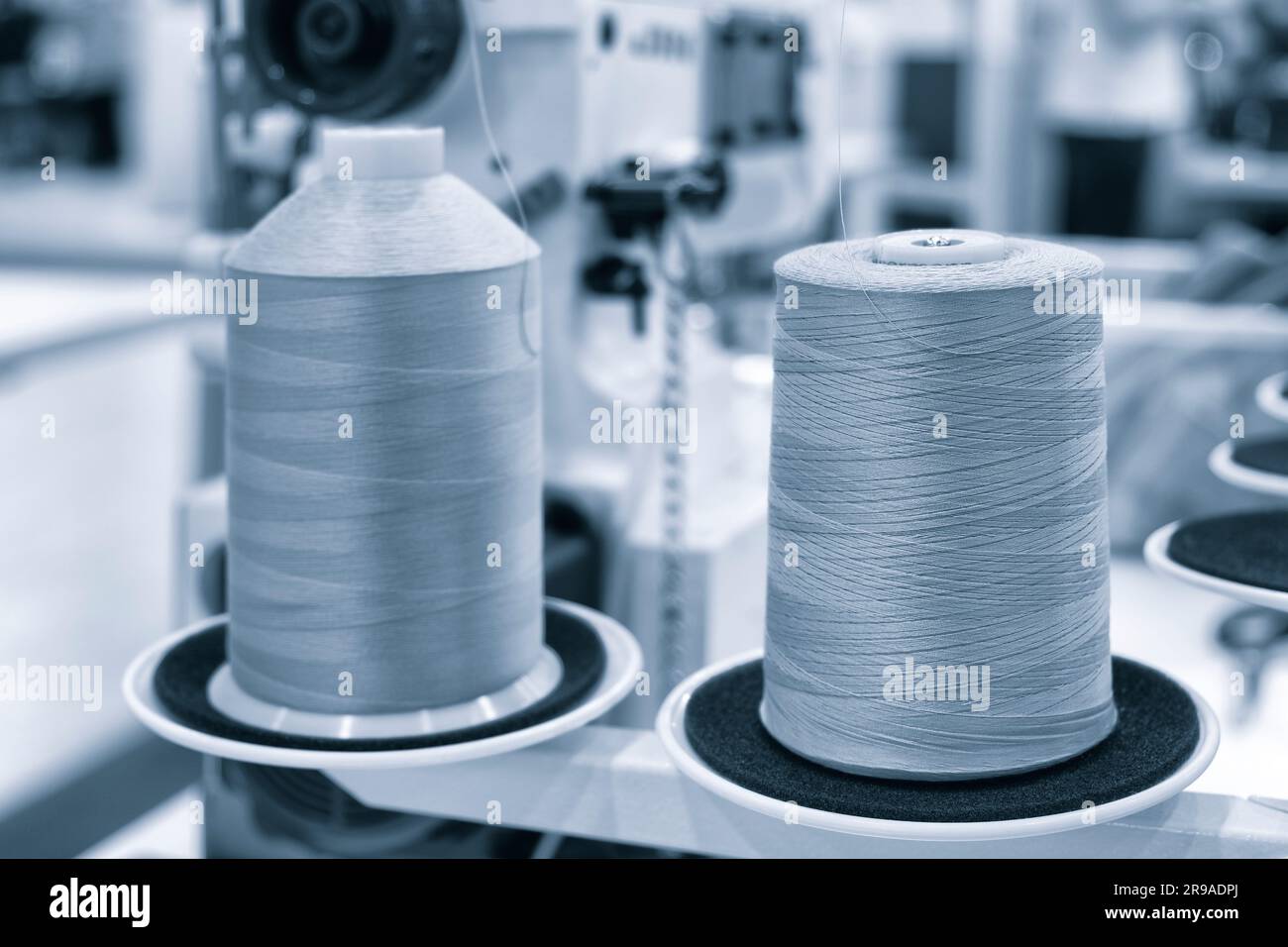Reels of textile yarn blue thread at industrial weaving manufacturing ...