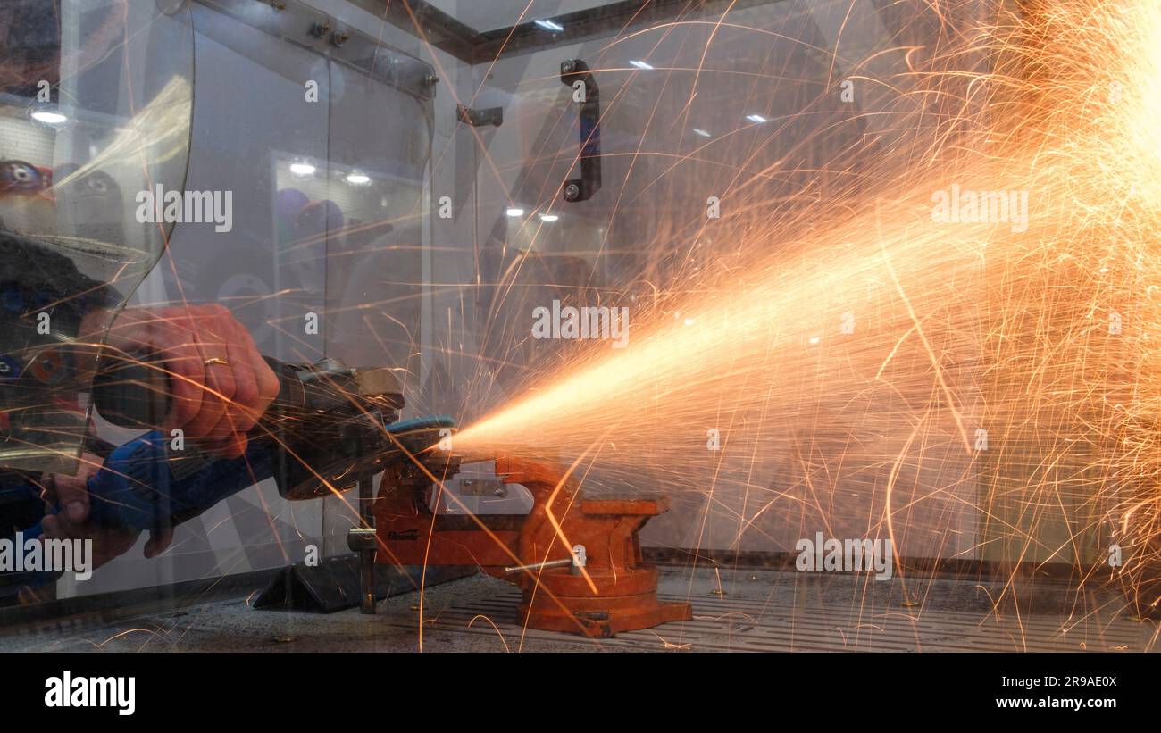 Worker cutting metal with grinder. Sparks while grinding iron. Electric ...