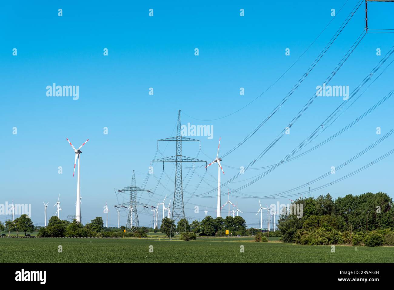 Wind turbines and power transmission lines with masts in Germany Stock ...