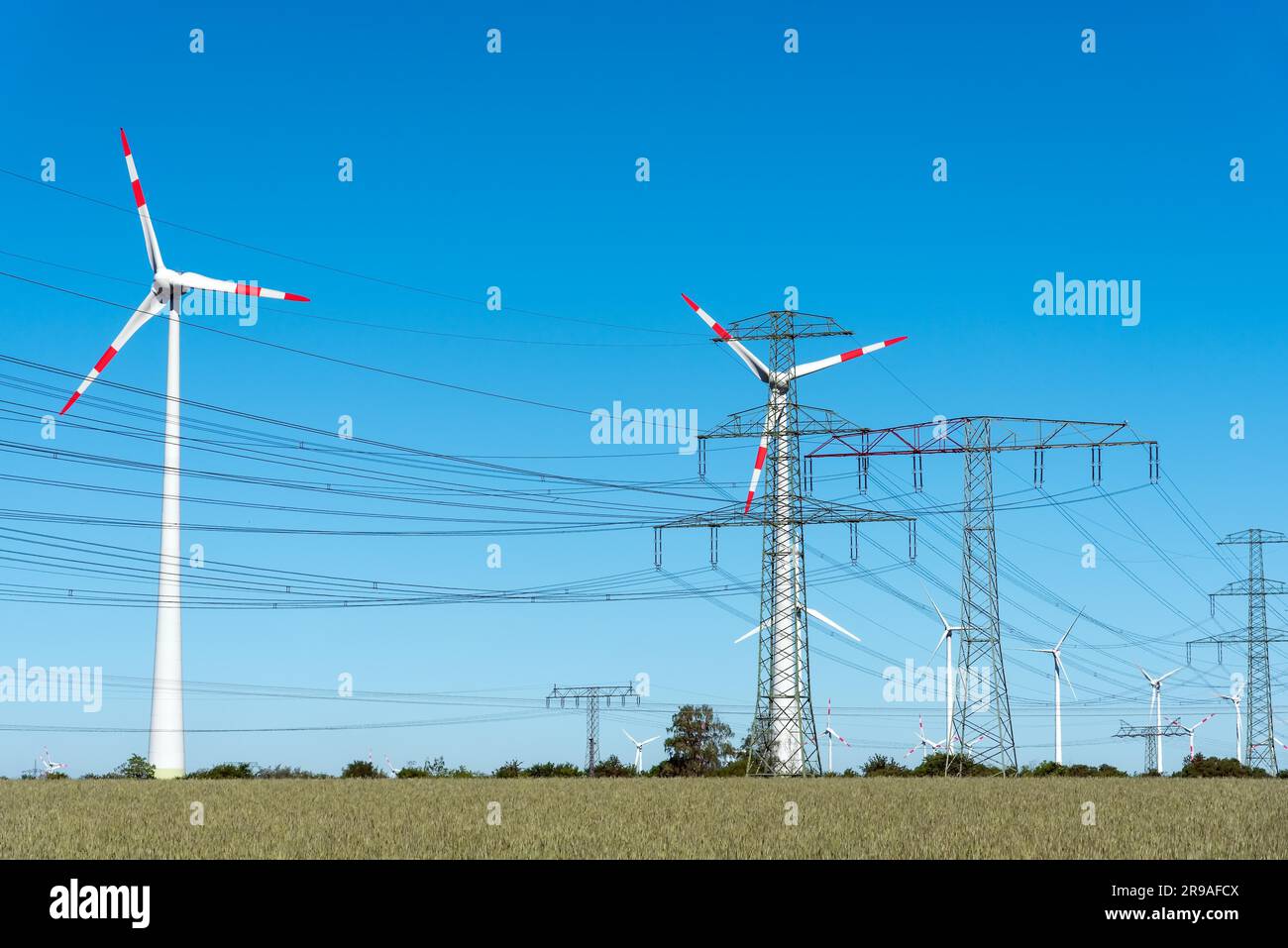 Wind turbines and power transmission lines with masts in Germany Stock ...