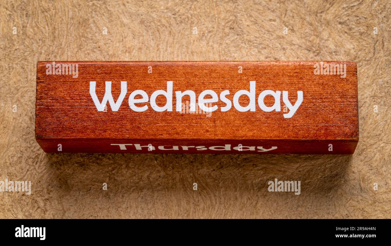 Wednesday and Thursday text on wooden block against handmade bark paper ...