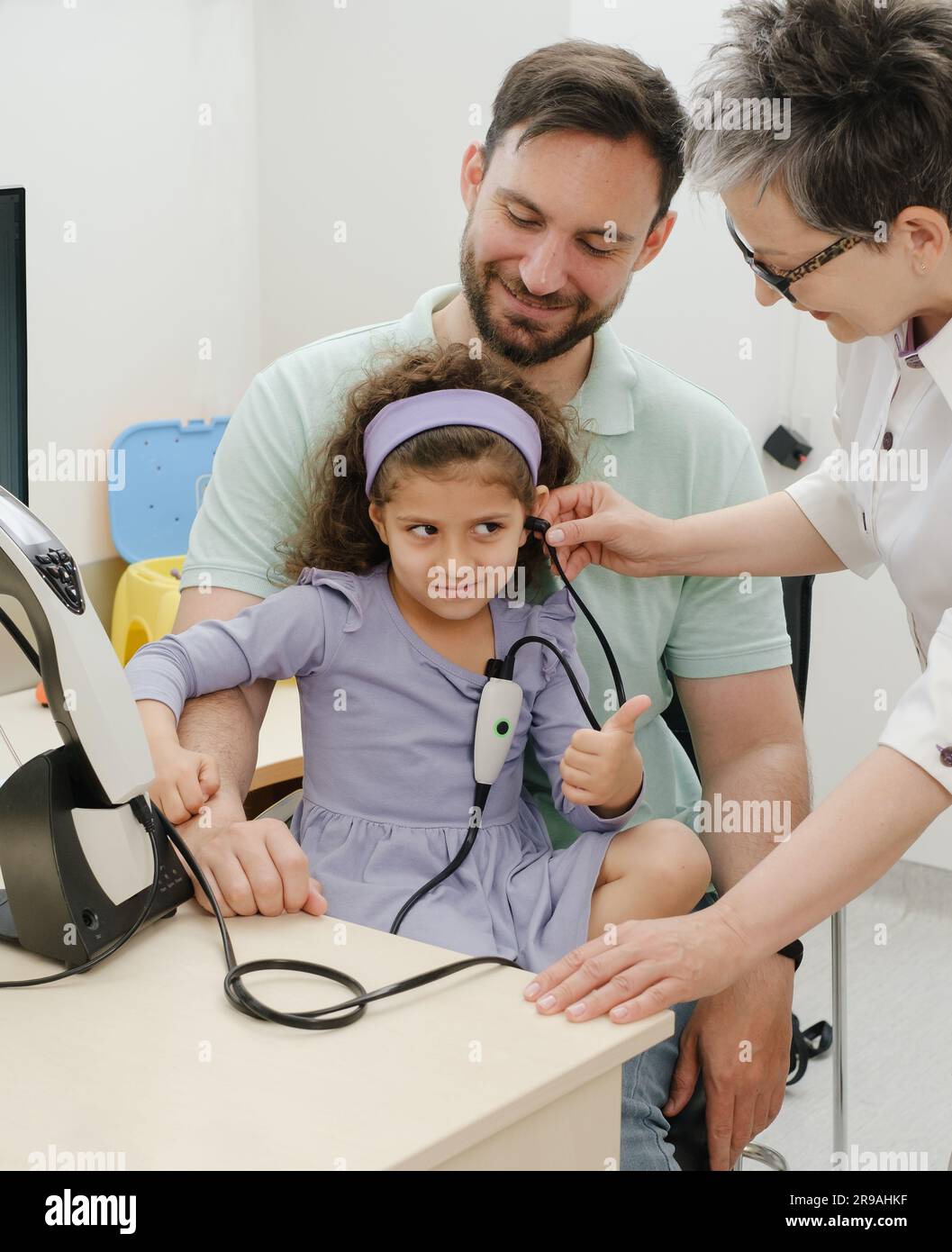 Child hearing test. Doctor audiologist examineing kids ear and assess ...