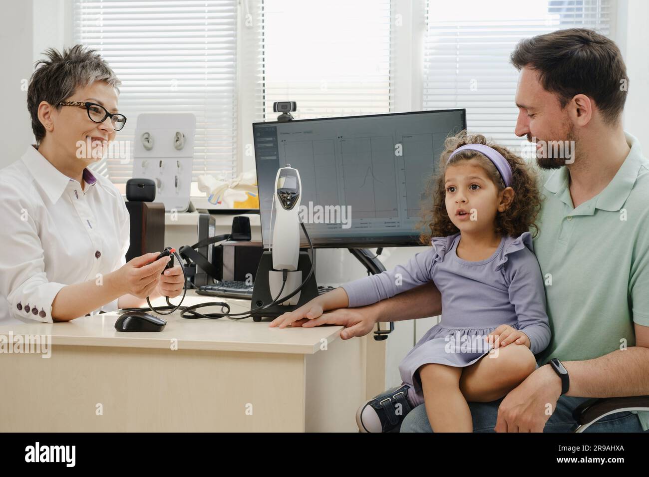 Child hearing test. Doctor audiologist consulting father of girl ear ...
