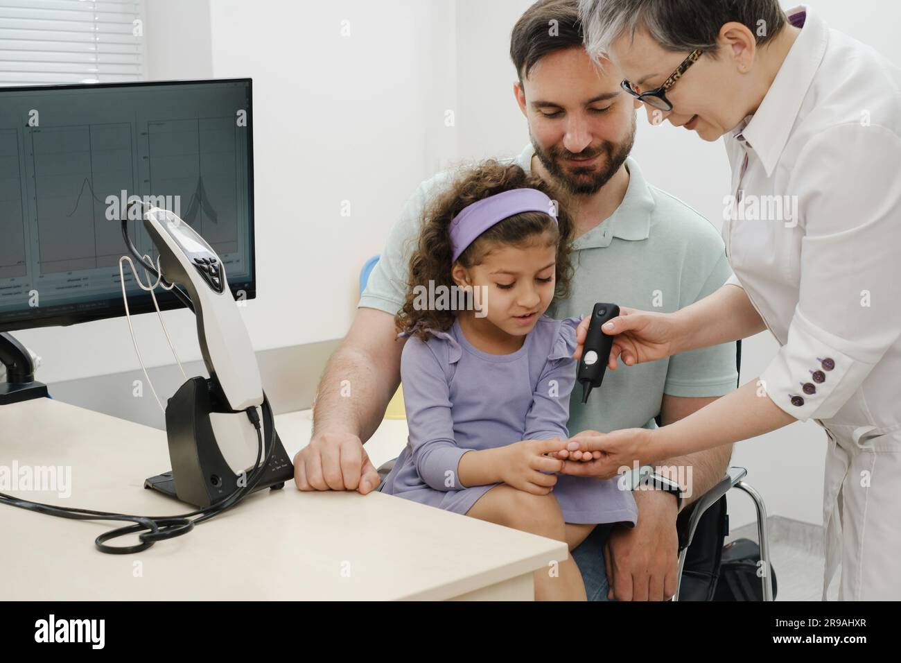Child hearing test. Doctor audiologist examineing kids ear and assess ...