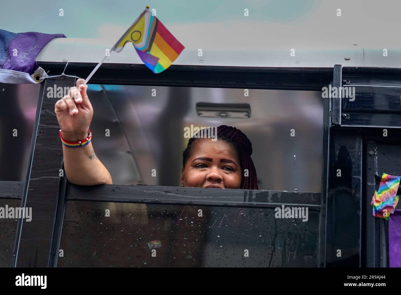 A paradegoer waves a flag out the window of a bus during Chicago's ...