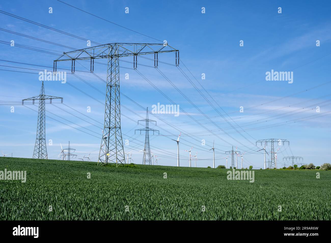 Power lines with wind turbines behind them seen in Germany Stock Photo ...