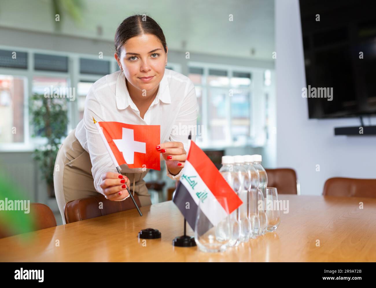 Female secretary places flags of the Iraq and Switzerland flag on the ...