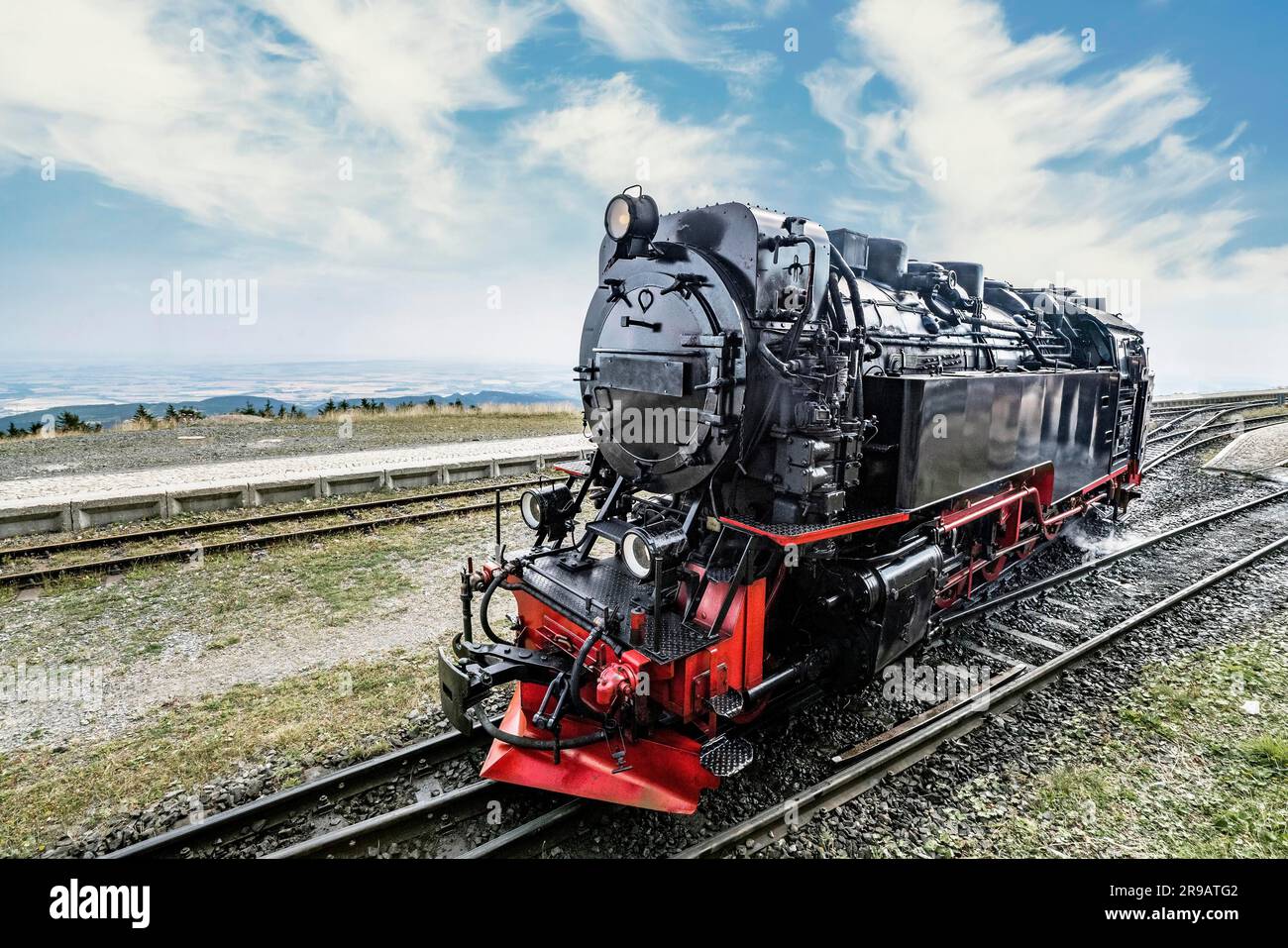 Locomotive on railroad tracks at a station under a blue sky Stock Photo ...