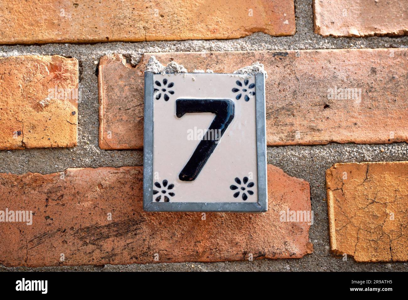 Sign with the number 7 house number hanging on a brick wall Stock Photo ...