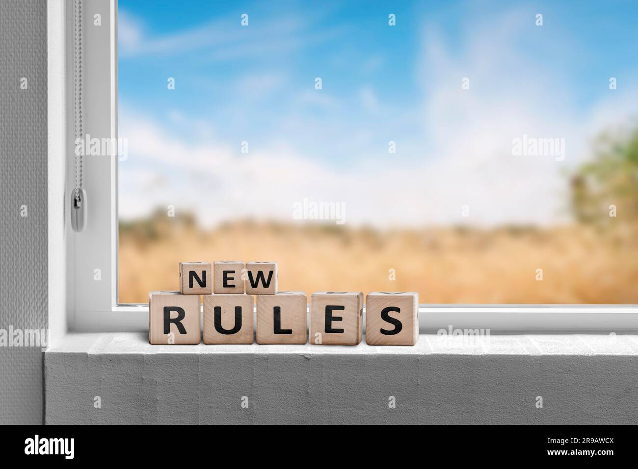 New rules sign in a window with a view to fields under a blue sky Stock ...