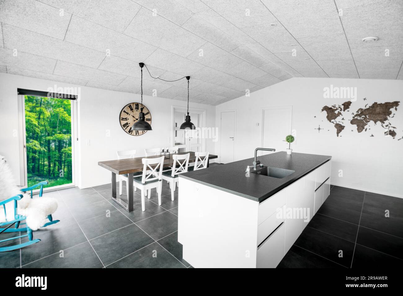 Large kitchen environment with a dinner table and a view to green ...