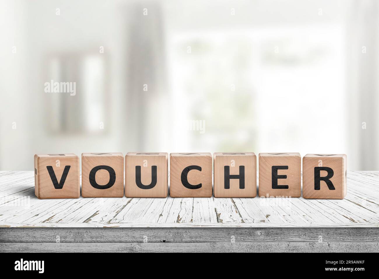 Voucher sign in a bright room on a white painted table made of wood ...