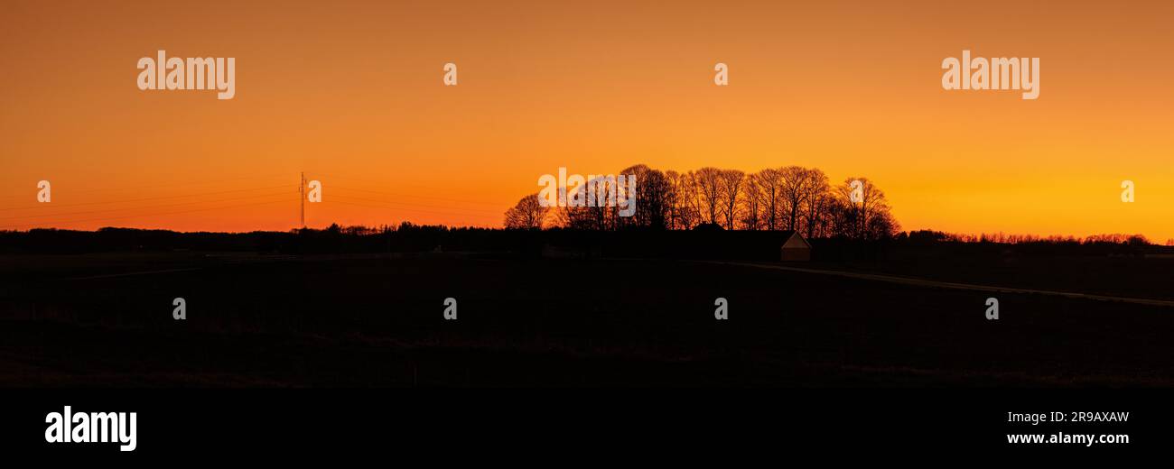 Warm countryside panorama sunset in a countryside landscape with tree ...