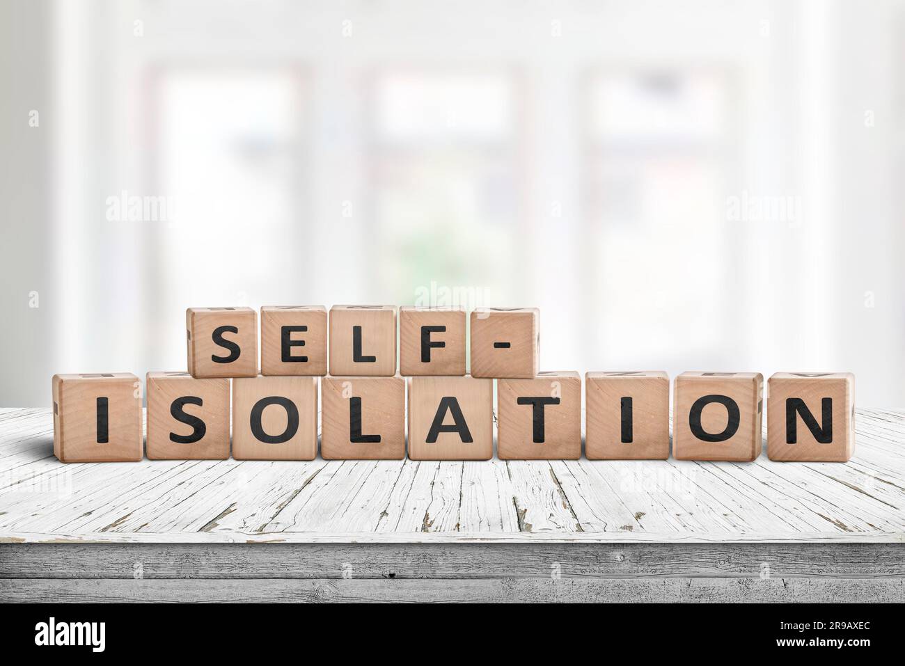 Self-isolation sign on a desk in a bright living room on a sunny day ...