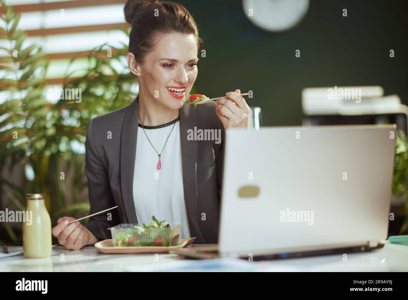 Sustainable workplace. smiling modern woman worker in a grey business ...