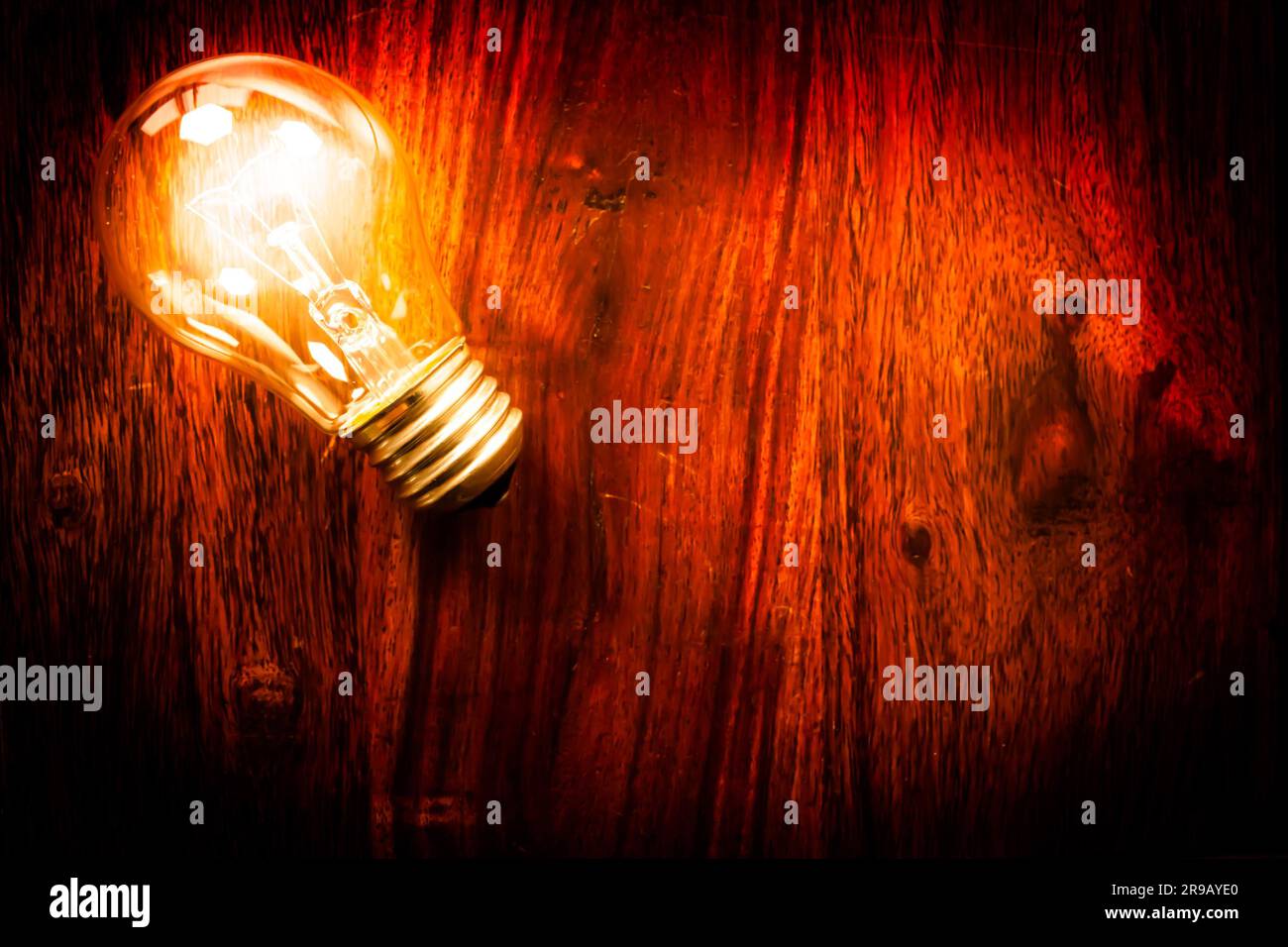 Bright light bulb on a wodden table Stock Photo - Alamy
