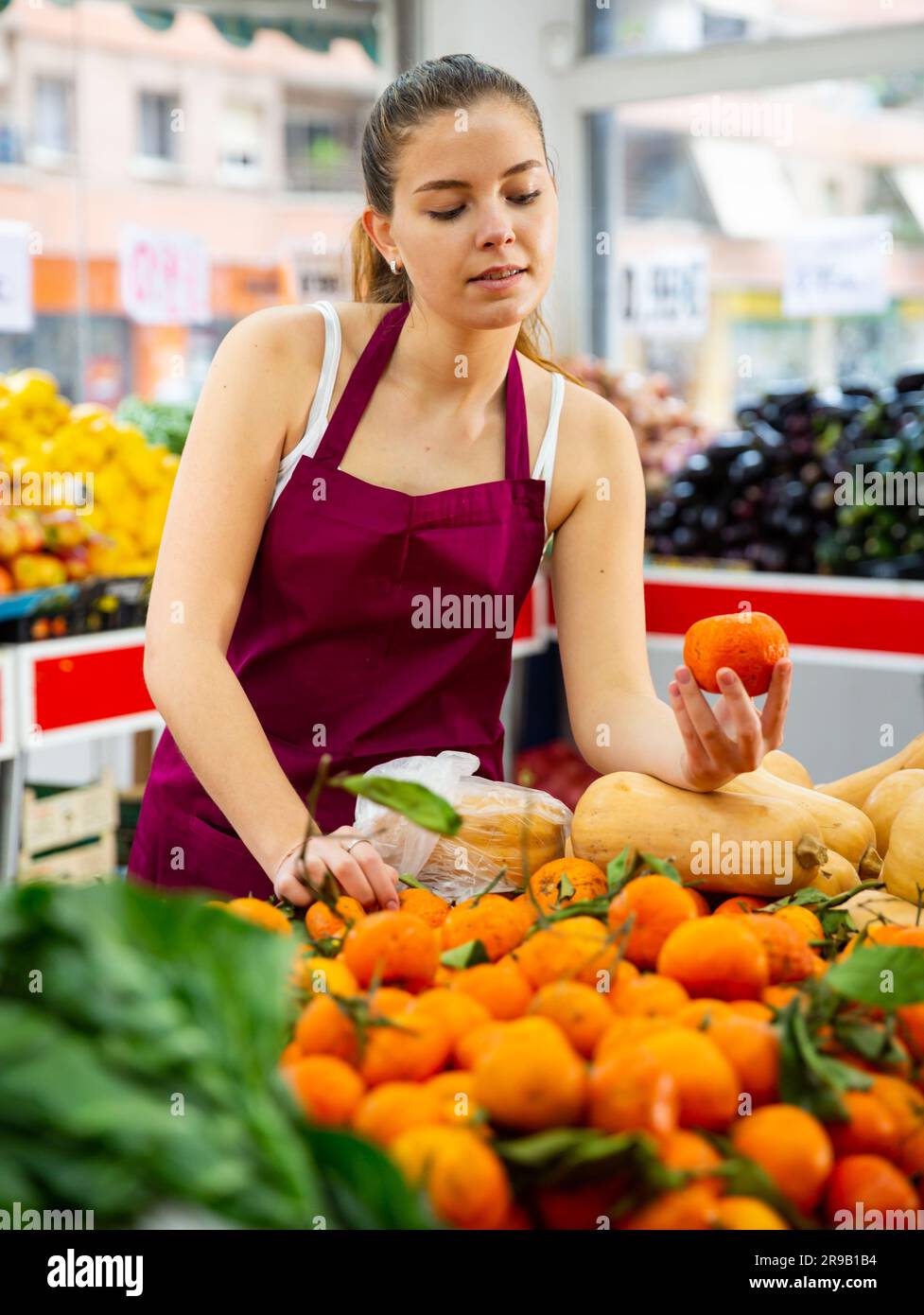 Cheerful women employees in uniform holding fresh mandarines Stock ...