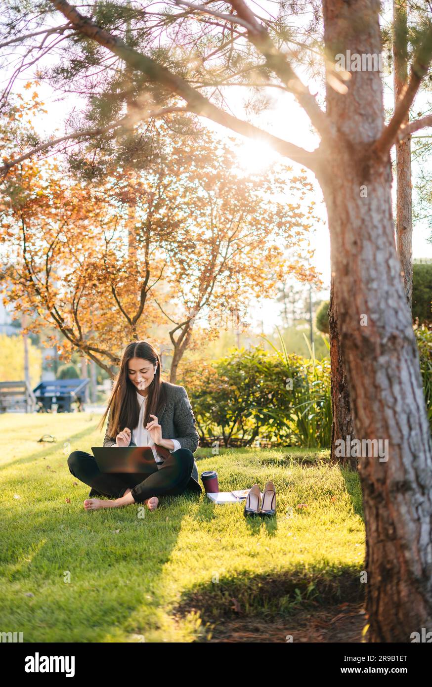 A Woman doing an online meeting in the Park, Surrounded by Autumn Trees ...