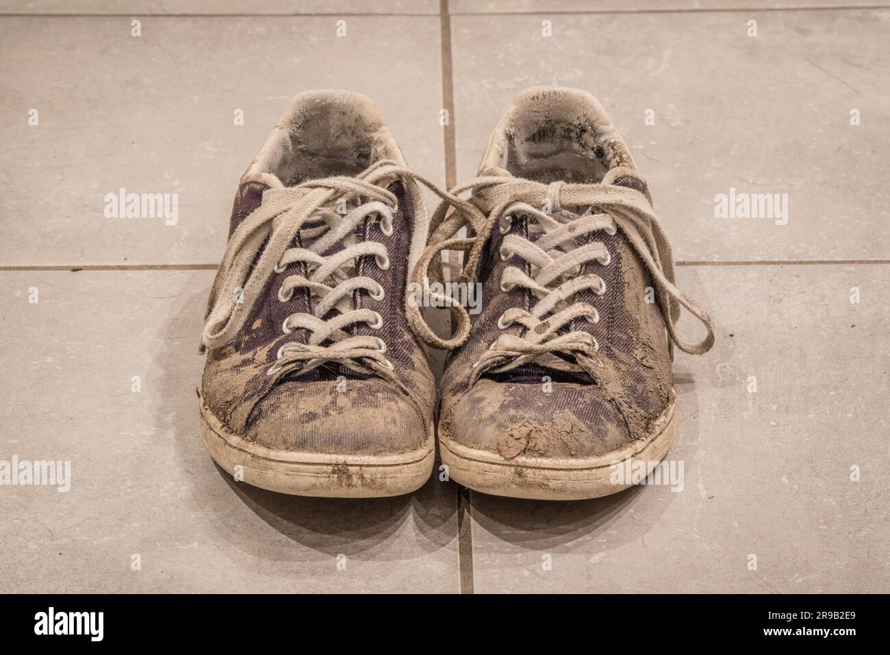 Pair of dirty shoes with mud on the floor Stock Photo - Alamy