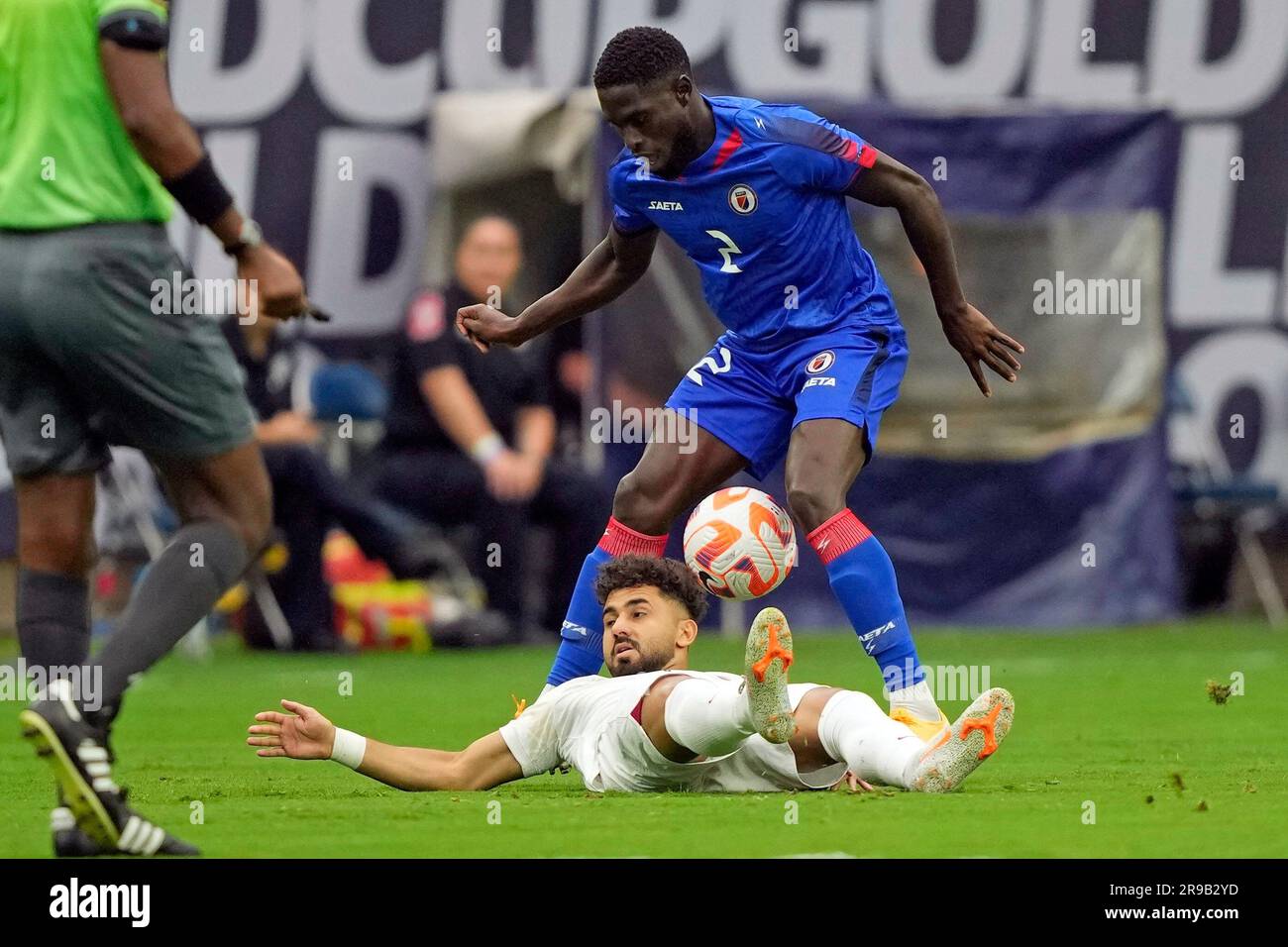 Qatar's Hazem Shehata, bottom, falls in front of Haiti's Carlens Arcus ...