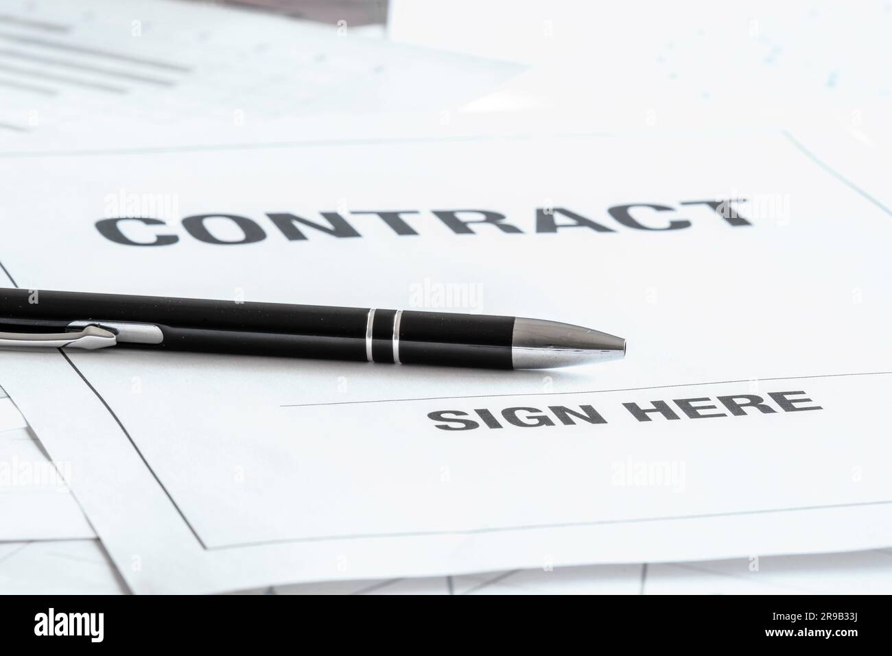 Black pen on a contract with a sign here area Stock Photo - Alamy