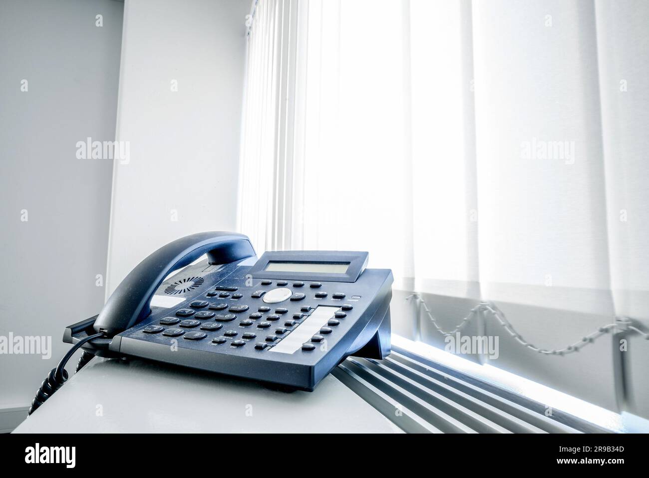 Telephone in an office window in bright light Stock Photo - Alamy