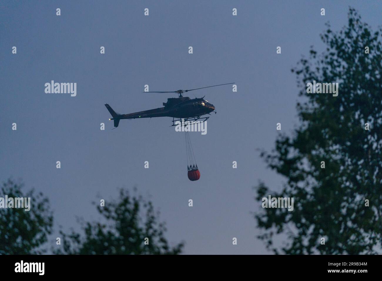 Broby, Sweden, 25 June, 2023 Helicopters water bombing a wildfire in ...