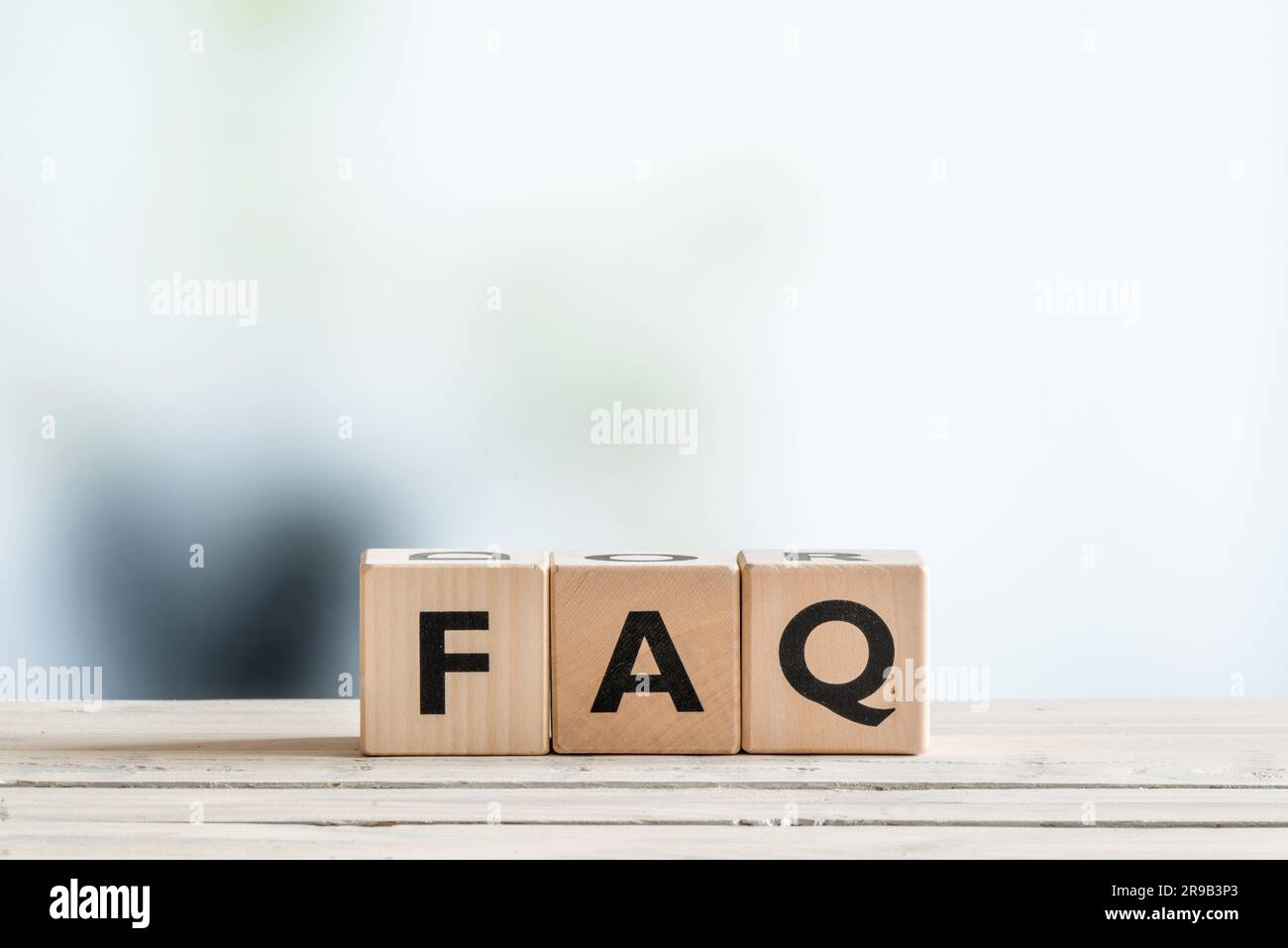 FAQ sign made of wood on an office table Stock Photo - Alamy