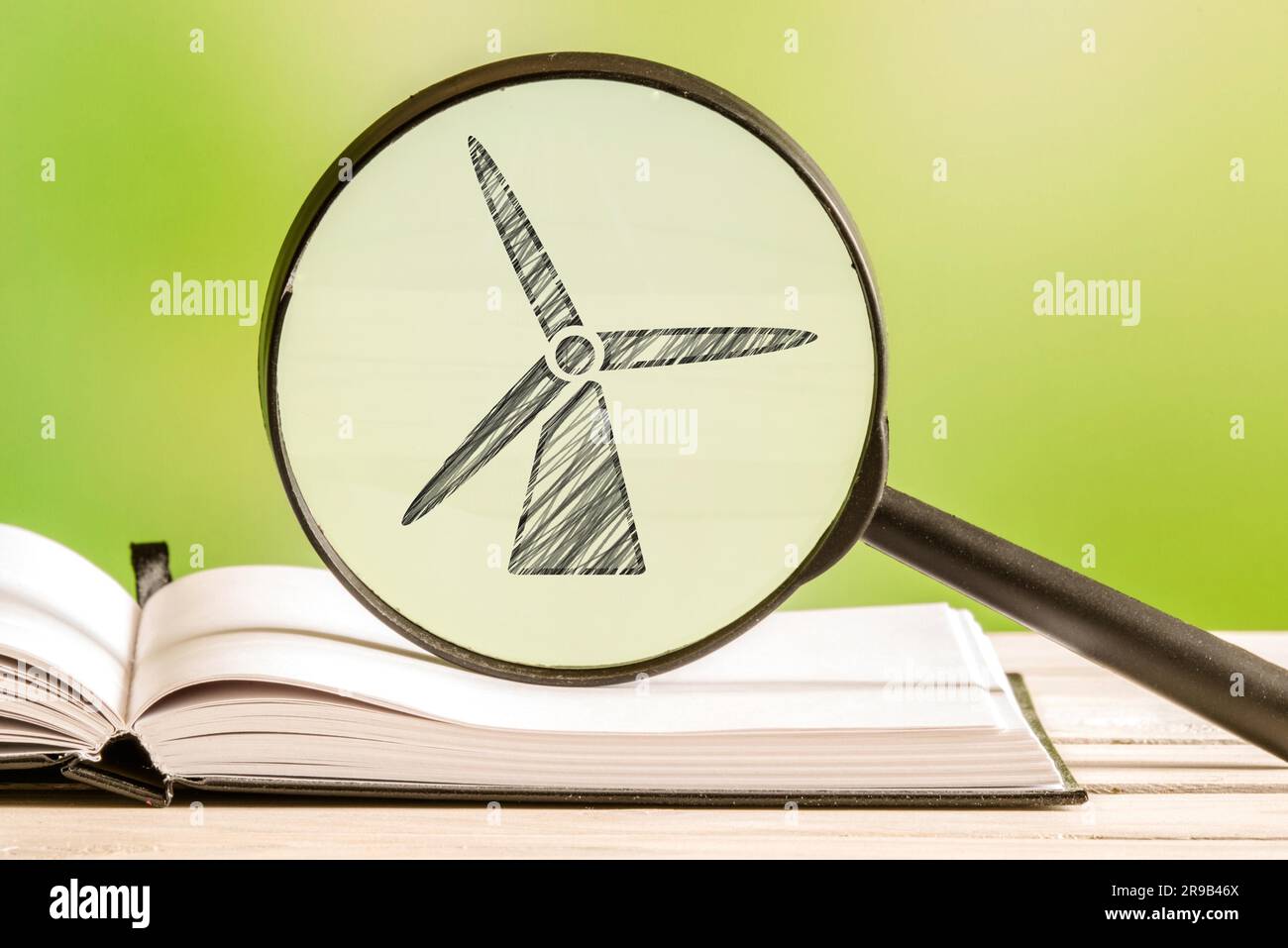 Energy research with a pencil drawing of a windmill in a magnifying ...
