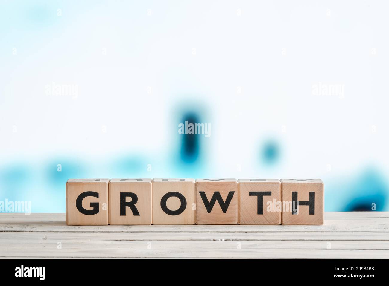 Growth sign made of wooden cubes on blue background Stock Photo - Alamy