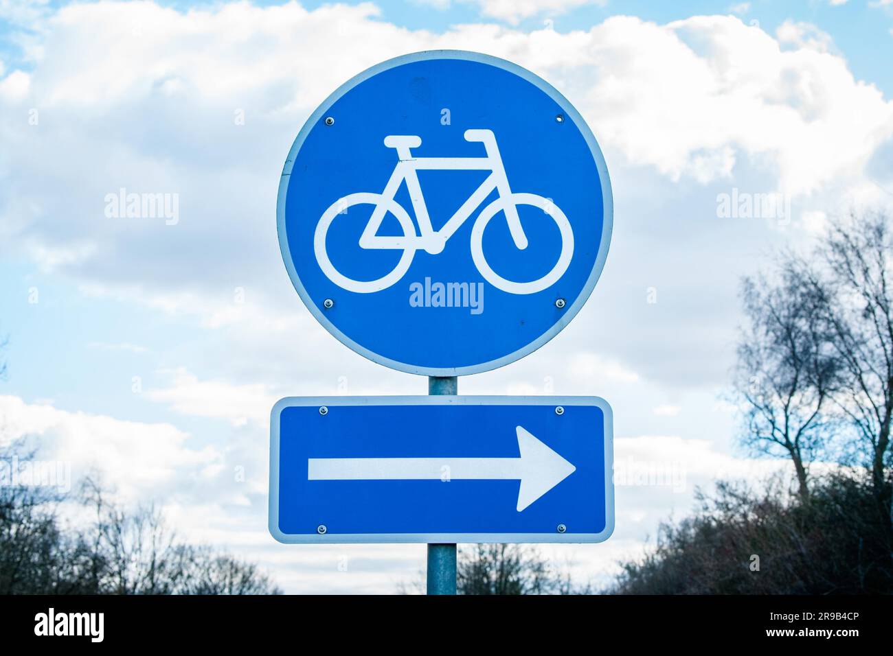 Bike sign in blue with a right pointing arrow Stock Photo - Alamy