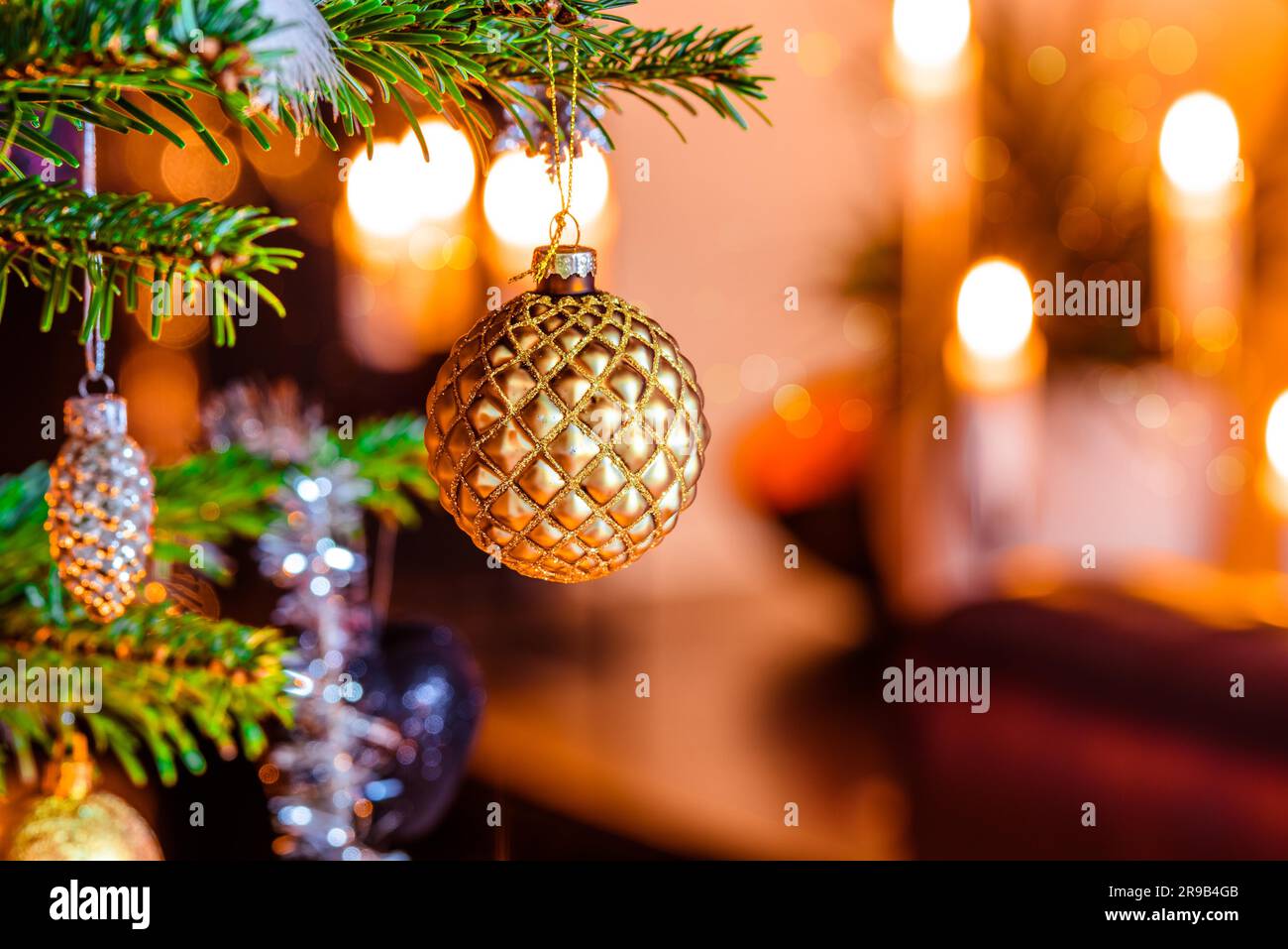 Christmas tree with a golden bauble and candlelights Stock Photo - Alamy