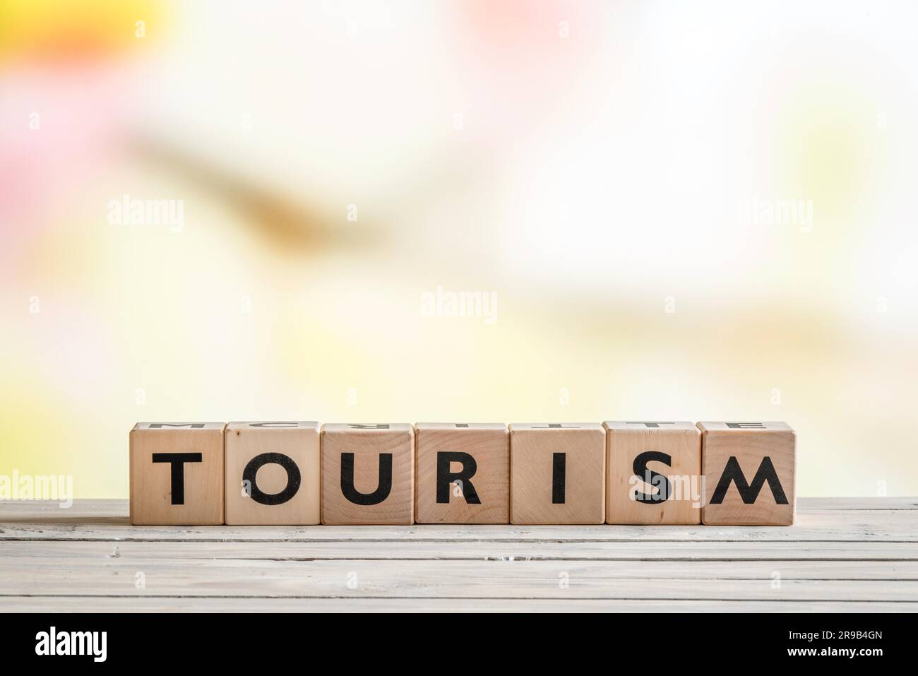 Tourism sign created with cubes on a wooden desk Stock Photo - Alamy