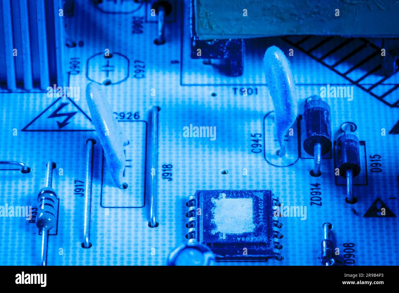 Capacitors and chips on an electrical device in blue colors Stock Photo ...