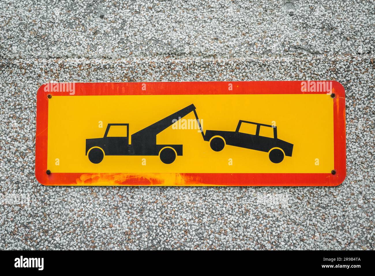Car removal sign in yellow and red on a concrete wall Stock Photo - Alamy
