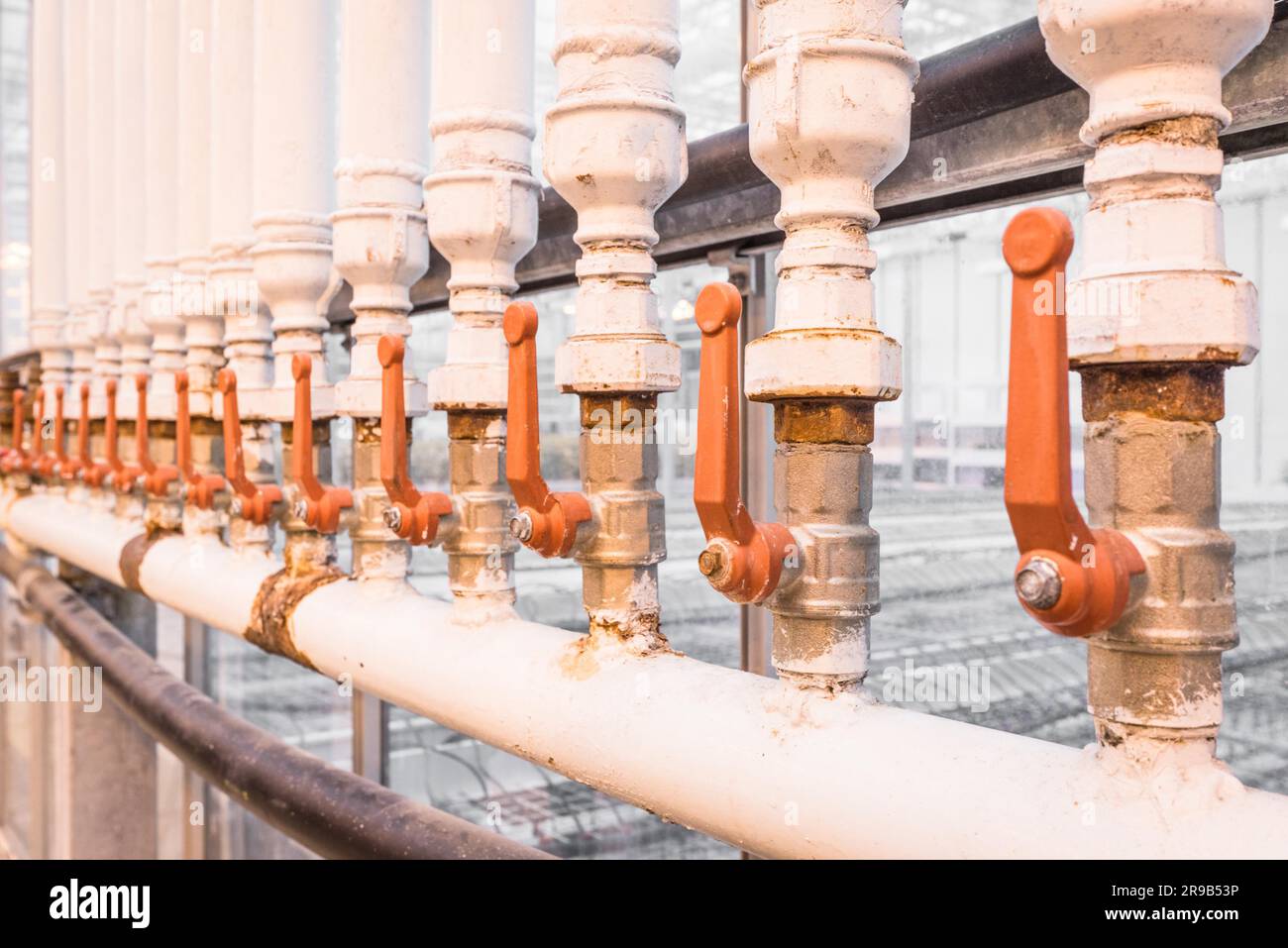 Orange handles on white pipes at a factory Stock Photo - Alamy