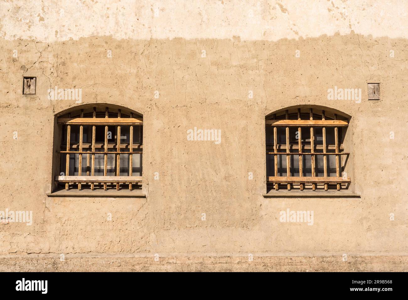 Prison with bars on the windows on a wall Stock Photo - Alamy
