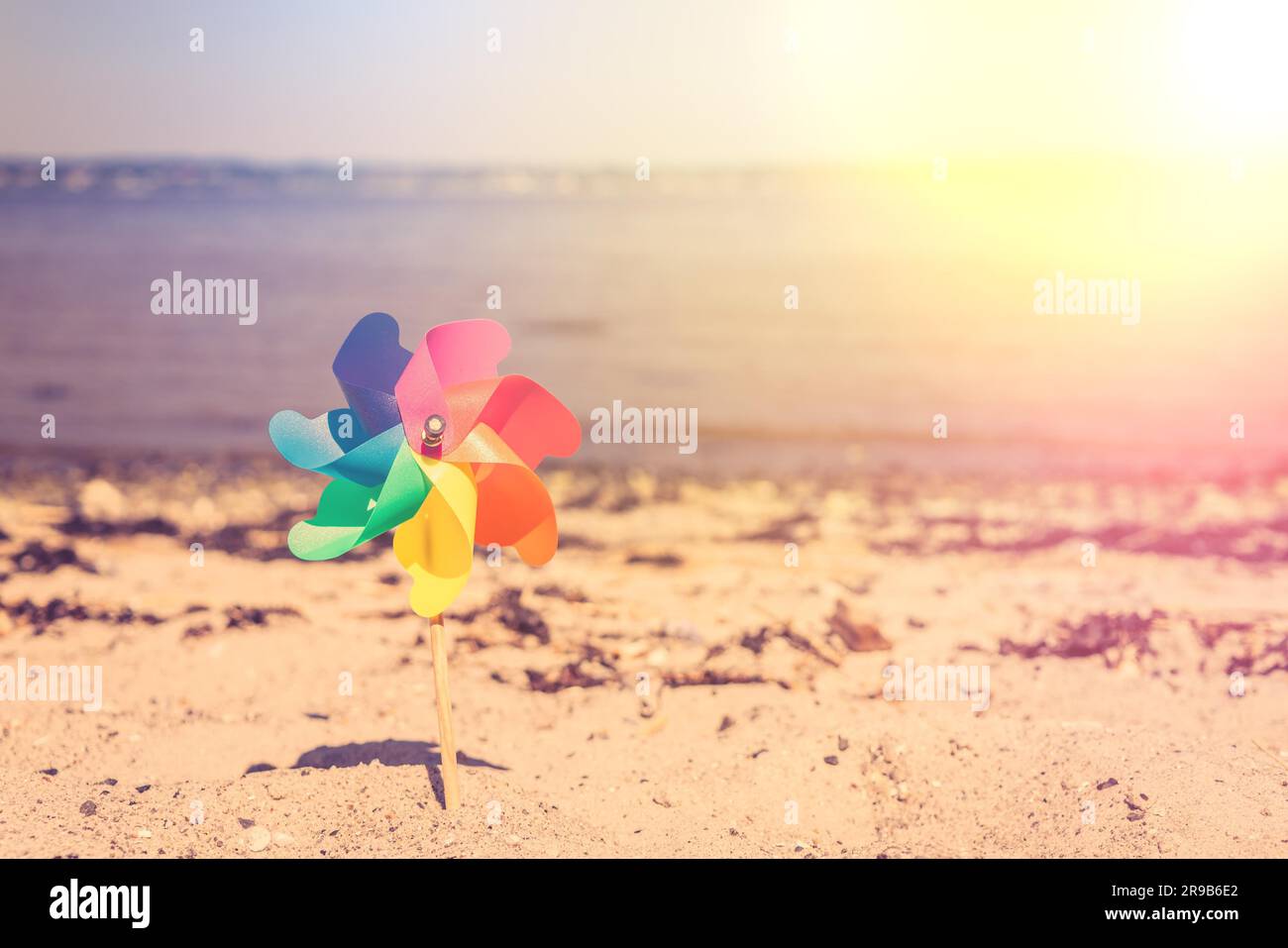 Summer toy windmill in the sand on a beach Stock Photo - Alamy