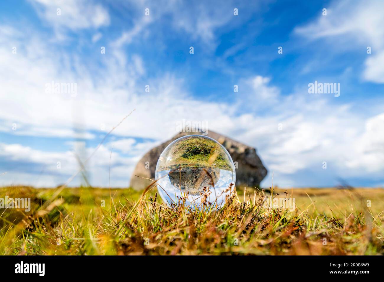 Glass orb on grass with reflection of a large rock in the summer Stock ...