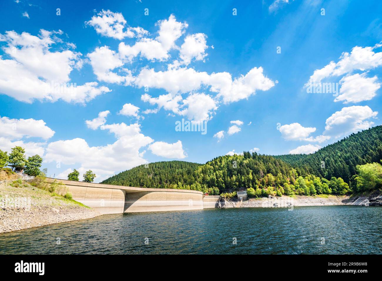 Lake landscape with a dam in summer with a forest in the background ...